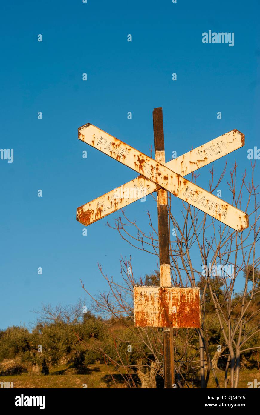 Train level crossing sign with blue sky in vertical Stock Photo - Alamy