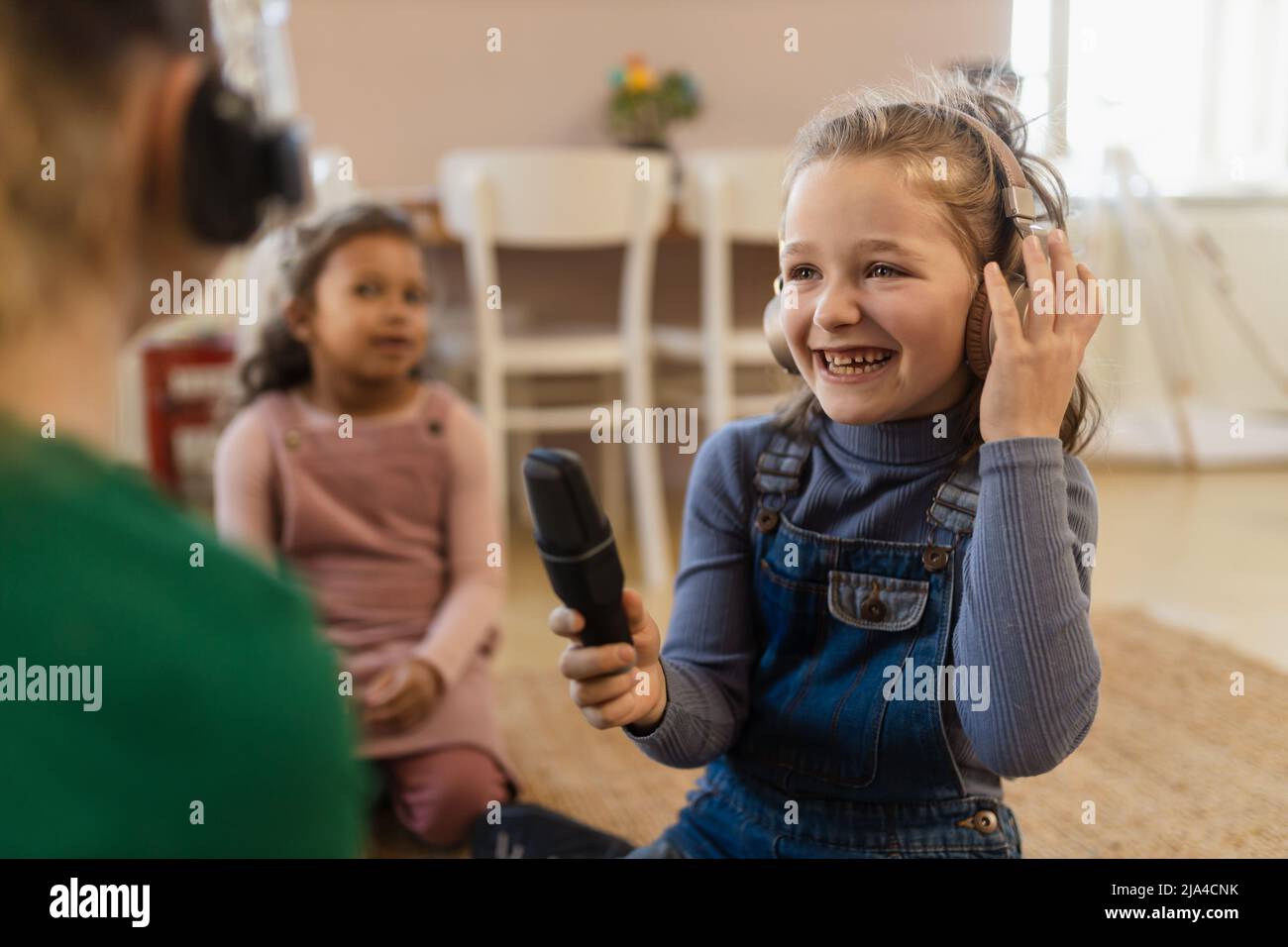 Little girls with headphones and microphone taking an interview, having ...