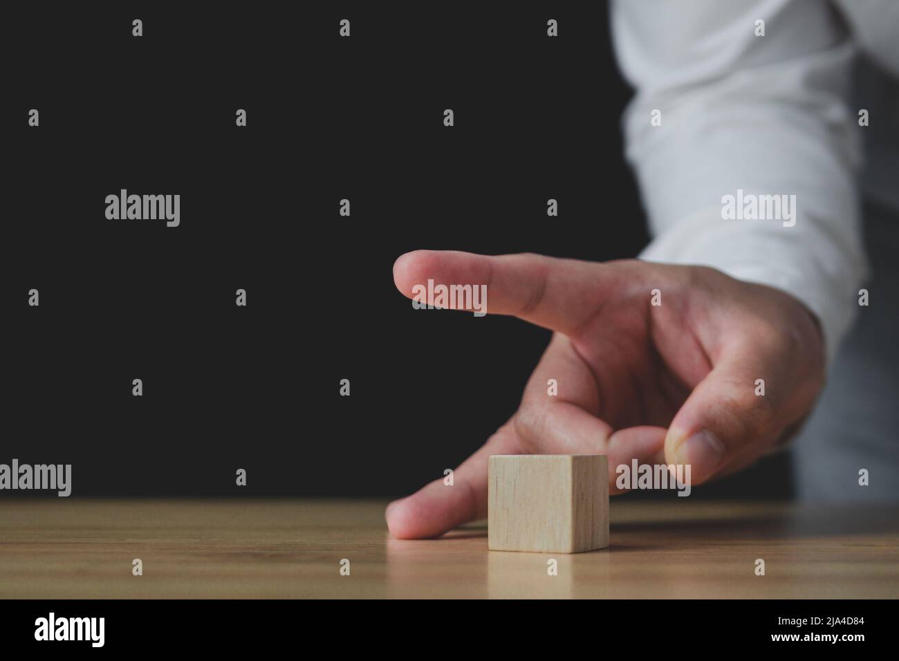 Someone uses fingers to flick a wood block. In the business, it shows a ...