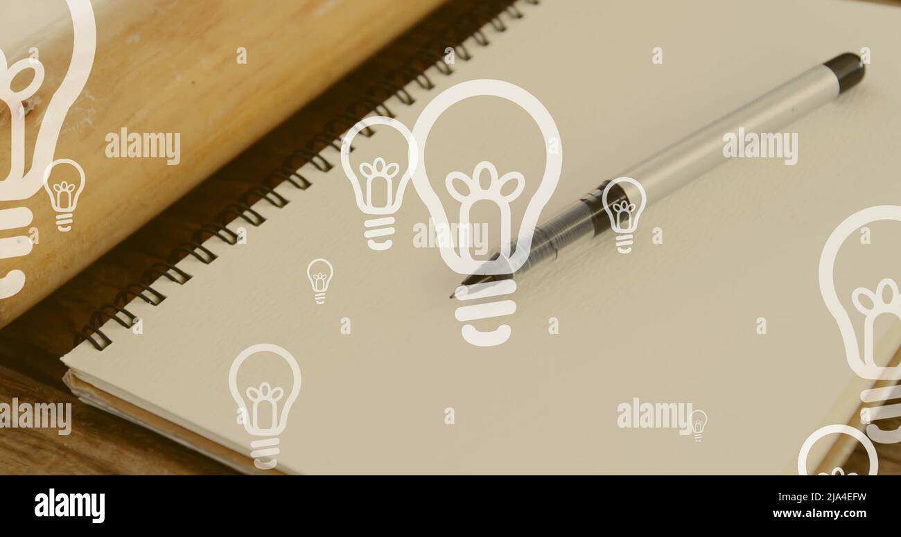 Image of lightbulb icons over notebook and pen Stock Photo - Alamy