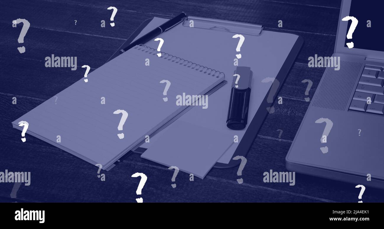 Image of question marks floating over notepads and laptop on office ...