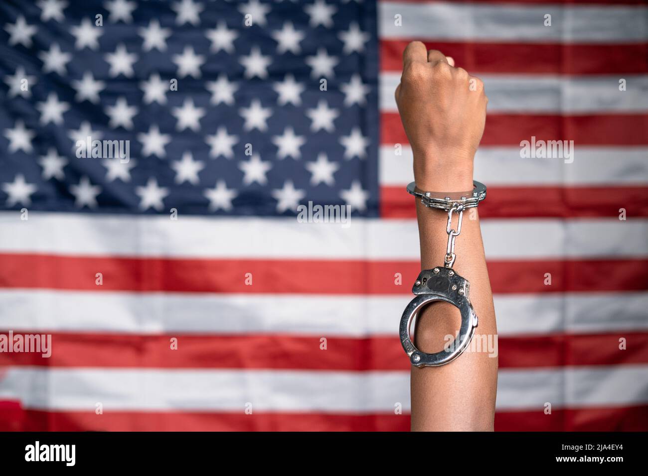 Close up shot of hanads rising with released cuffs against us or ...
