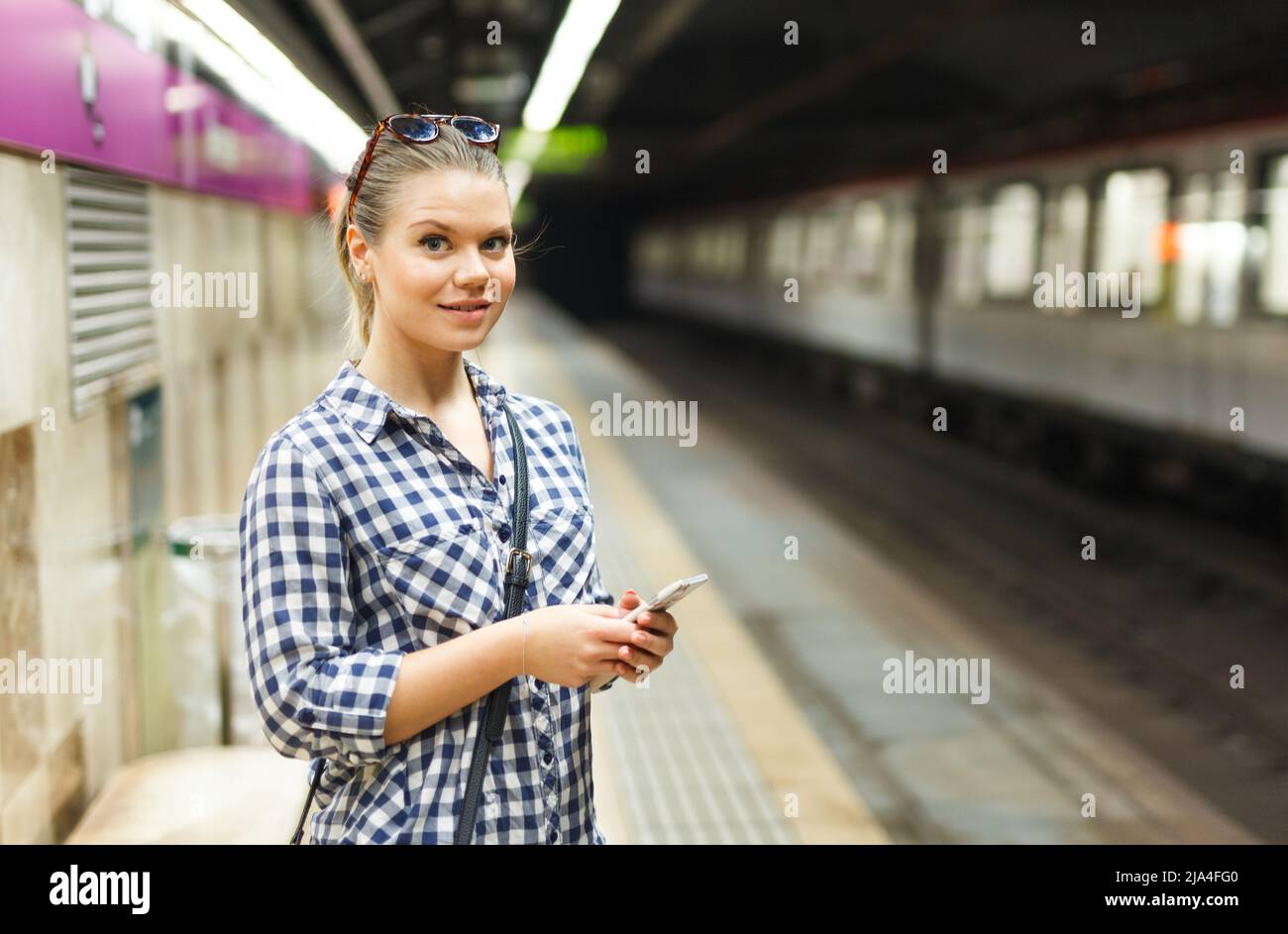 Girl waiting for train at metro station Stock Photo - Alamy