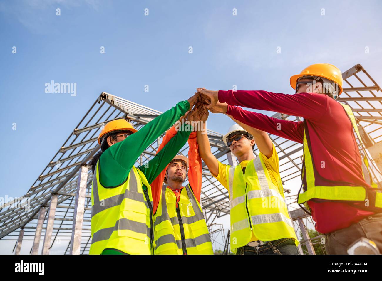 4 Workers, Architect and Engineer construction workers join hands while ...
