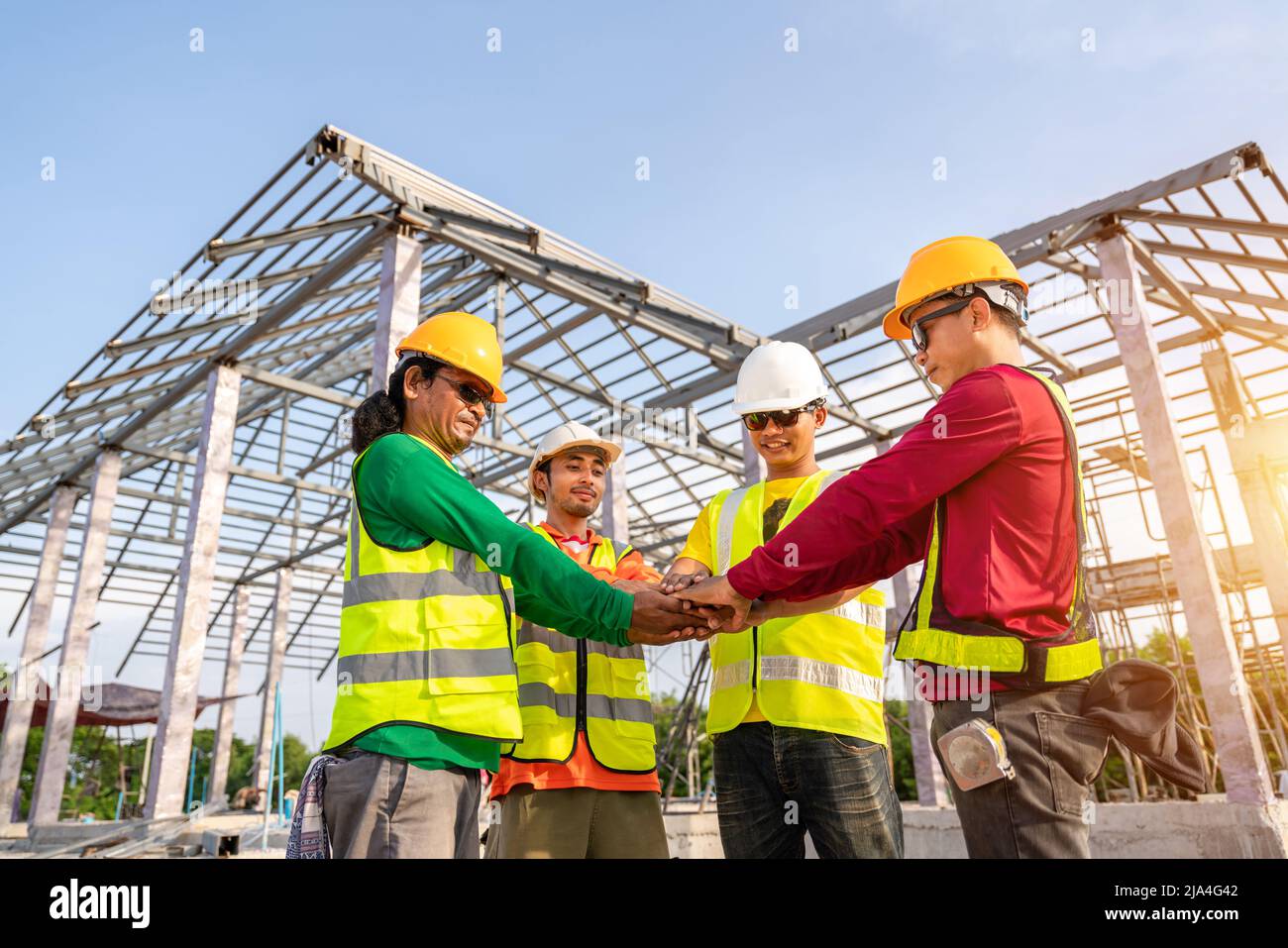 Architect and Engineer construction workers join hands while working at ...