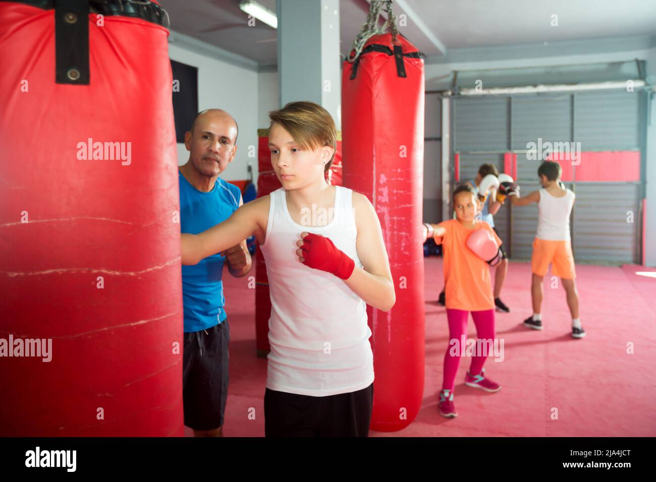 Boxing instructor and young children practicing blows Stock Photo - Alamy