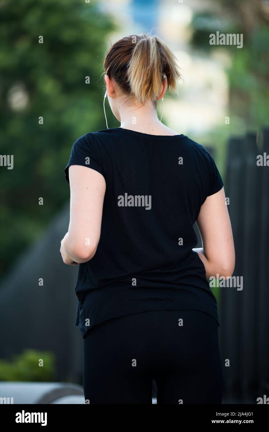 Back view of girl running with music Stock Photo - Alamy