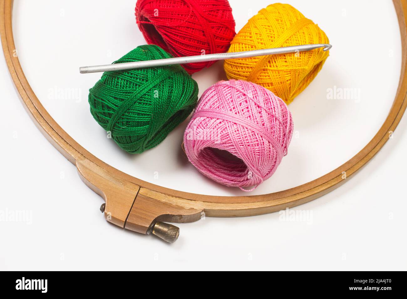 Colored yarn spools and a crochet hook on a white background Stock ...