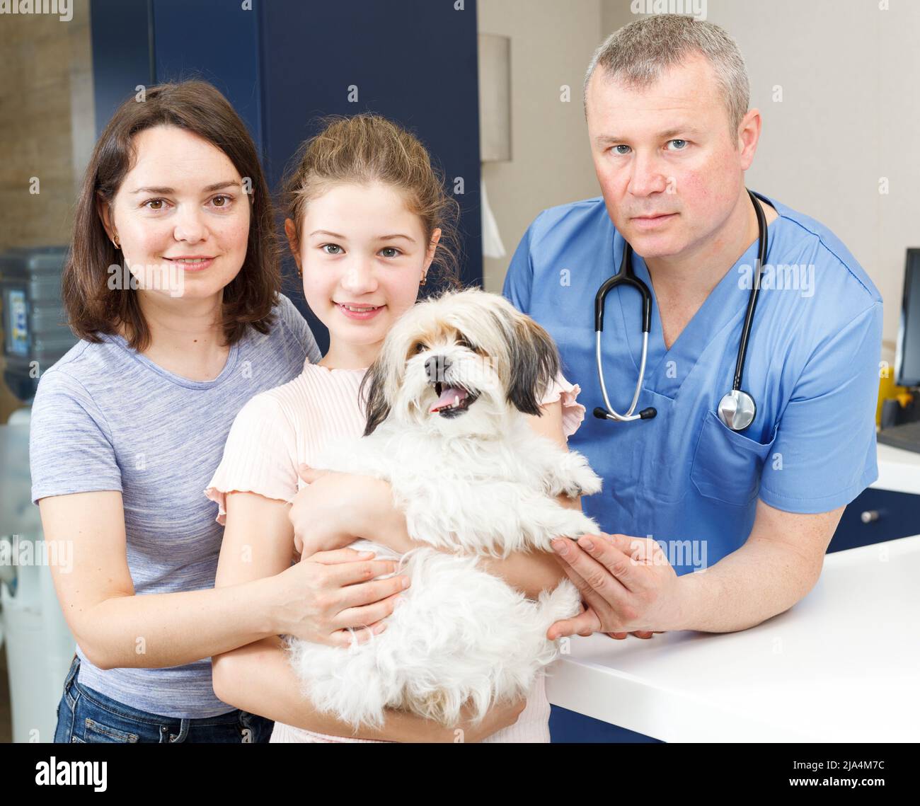 Smiling girl and mother with dog in vet clinic Stock Photo - Alamy