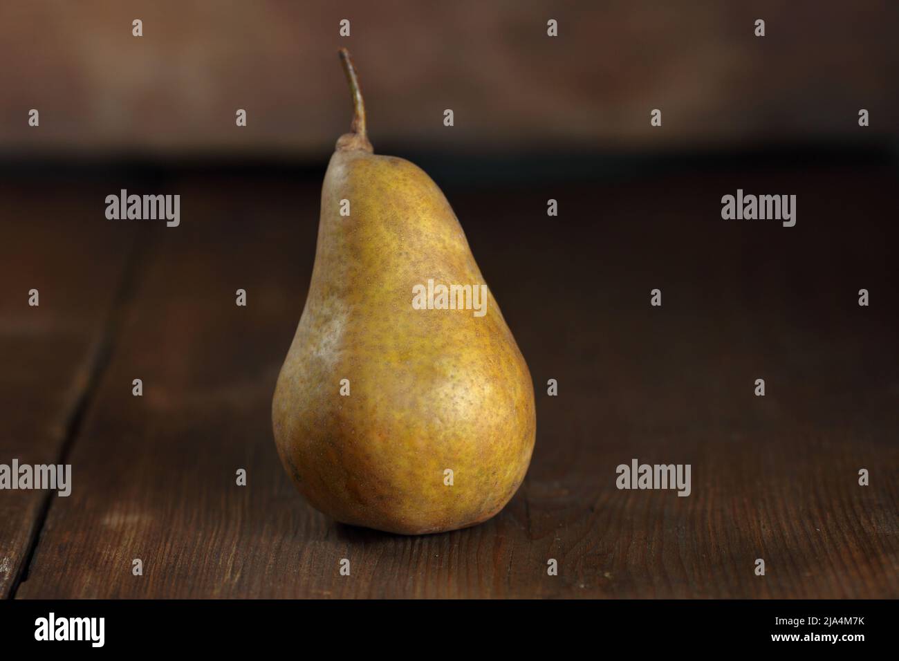 One bitten pear lying on a wooden table background a sacking Stock ...