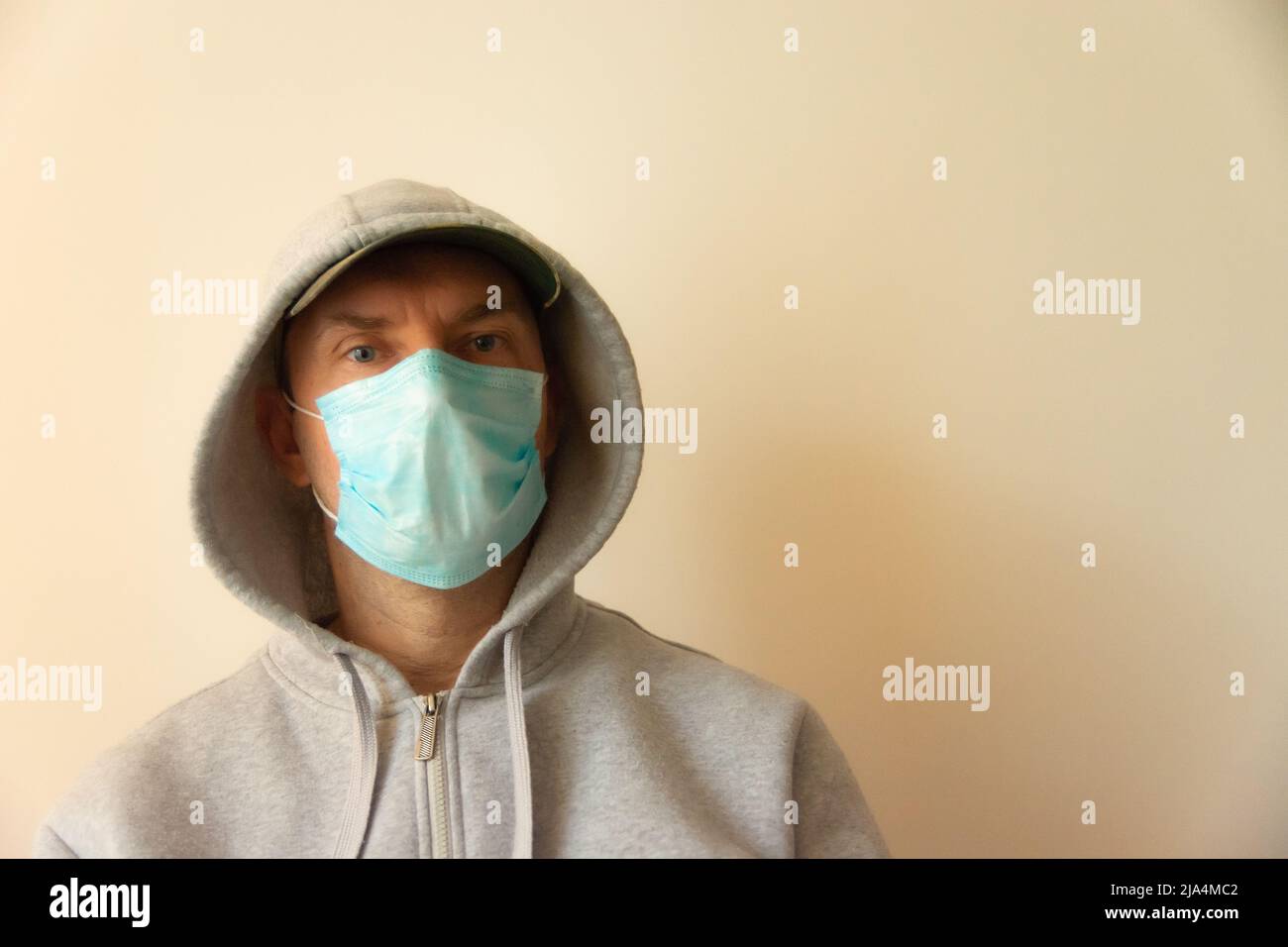 A man with a blue mask on his face and a hood on his head Stock Photo ...