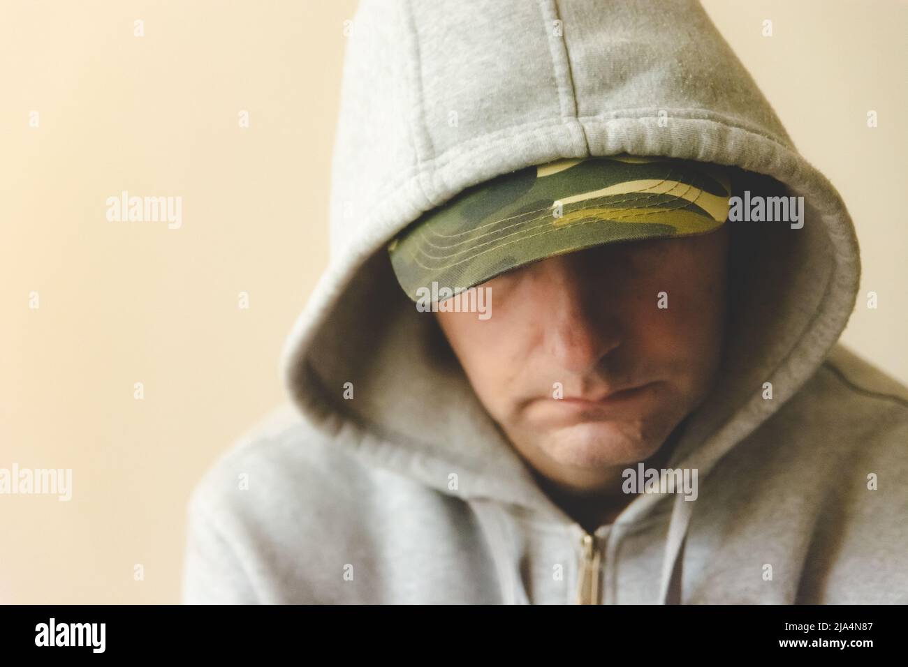 A sad man with his head lowered, Sharpness on the cap Stock Photo - Alamy