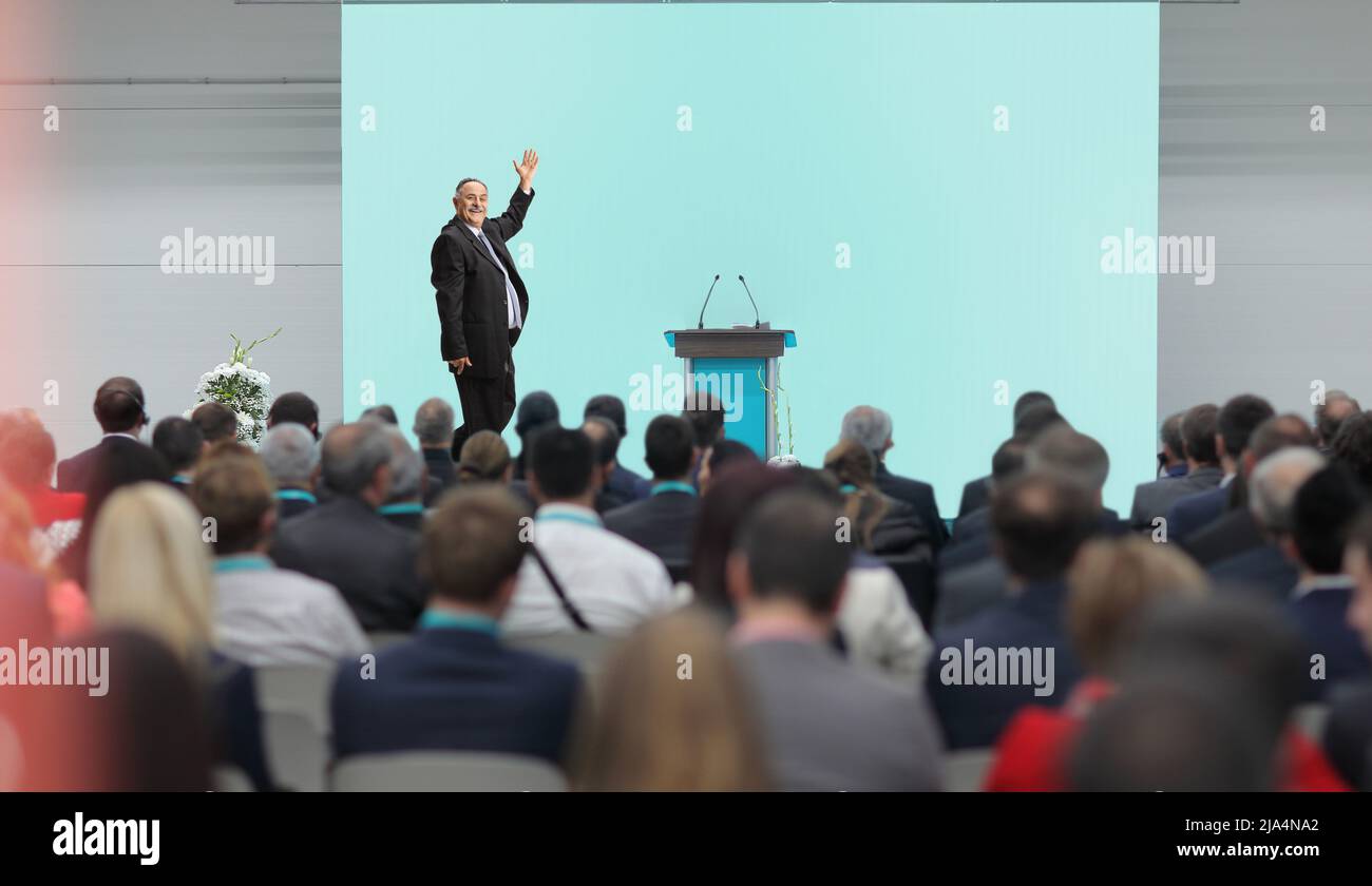 Politician on a stage waving at people sitting in the audience Stock ...