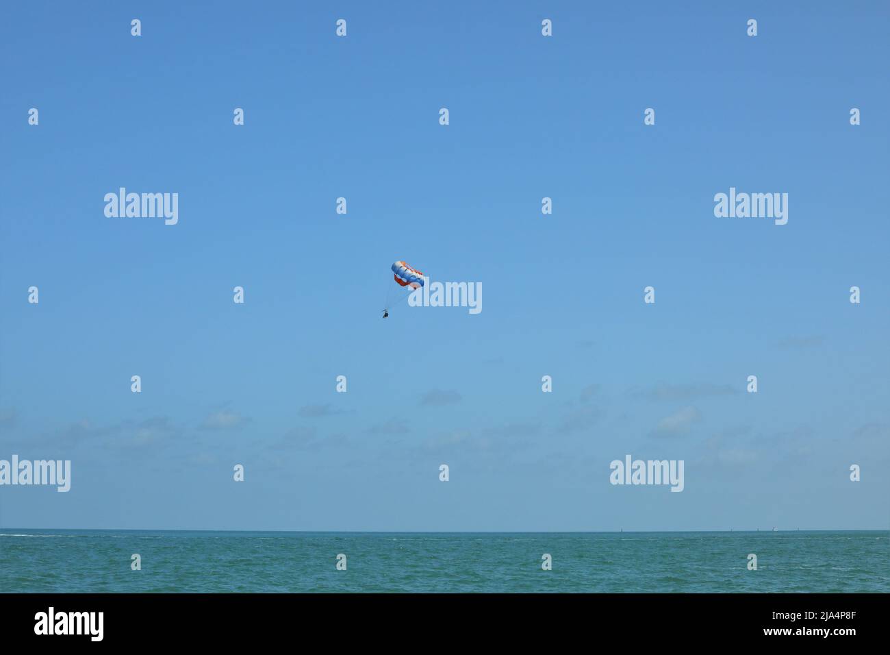 Paragliding in Key West Florida over azure water in sunny nice weather ...