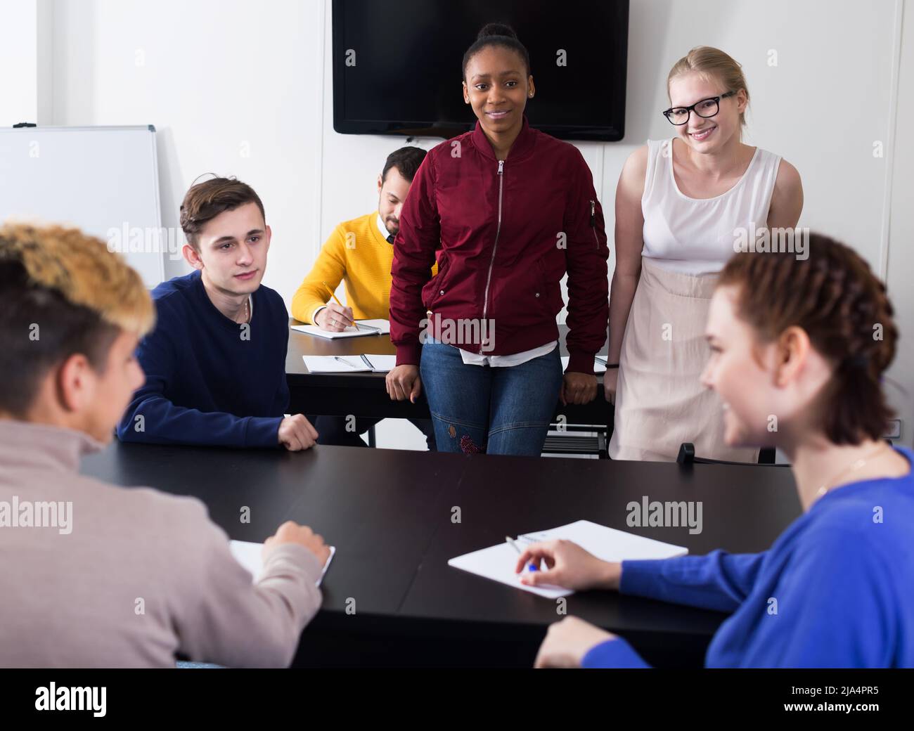 Fellow students talking in class Stock Photo - Alamy