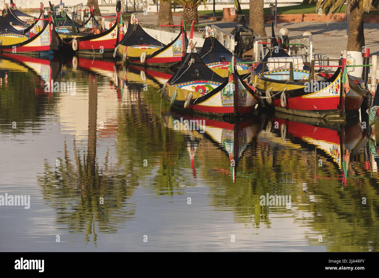 popular with tourists colorful Moliceiros boat moored along a canal in ...