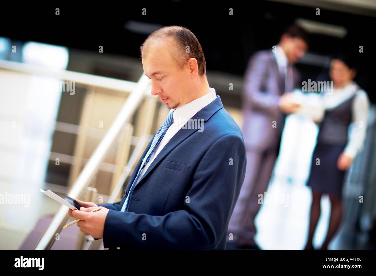 Happy smart business man with team mates discussing in the background ...