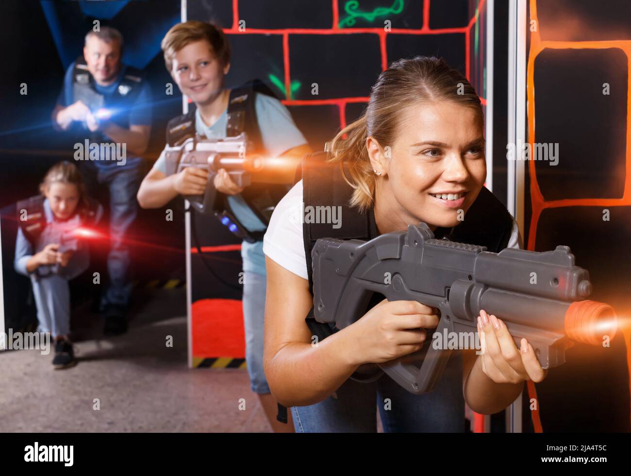 Happy young girl with laser gun during laser tag game with pla Stock ...