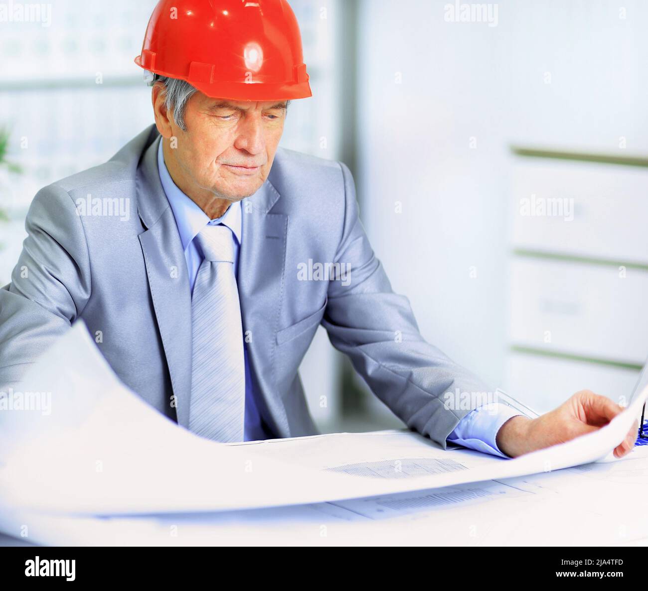 Engineer at the age of considering plans drawing and corrects them ...