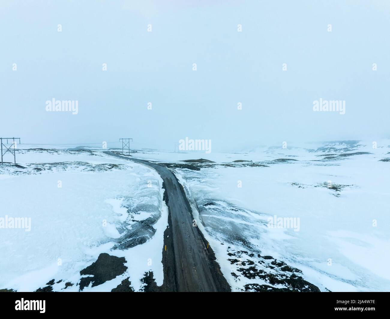 Endless road into the cloudy mountains and hills of Iceland during ...