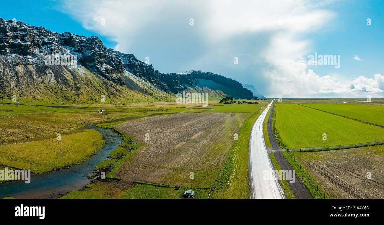 Endless road into the cloudy mountains and hills of Iceland during ...