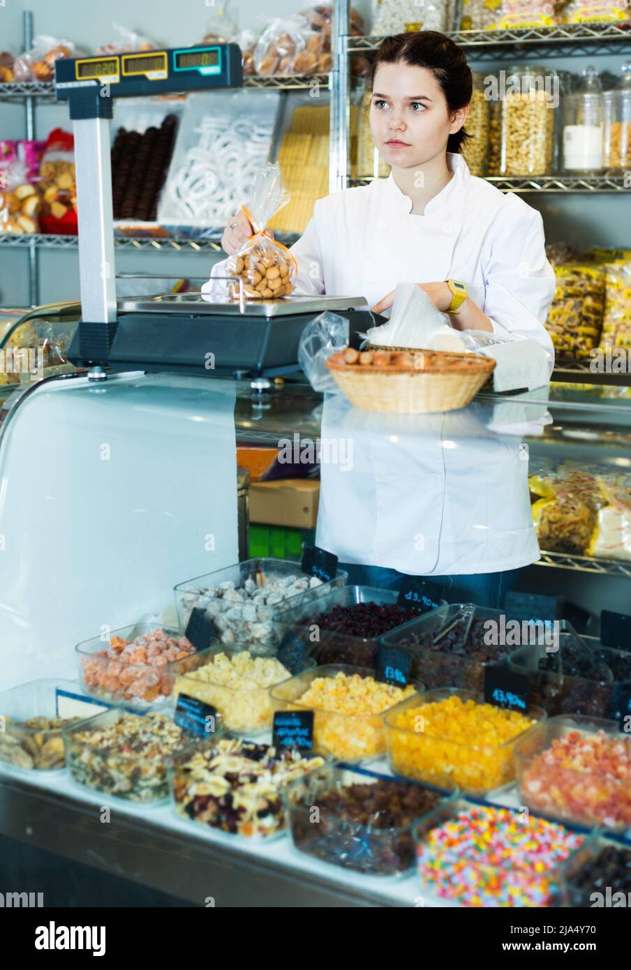 Girl in uniform selling candied fruits and nuts Stock Photo - Alamy