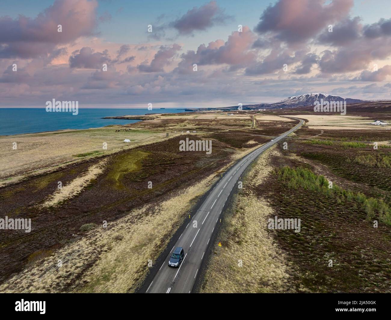 Endless road into the cloudy mountains and hills of Iceland during ...