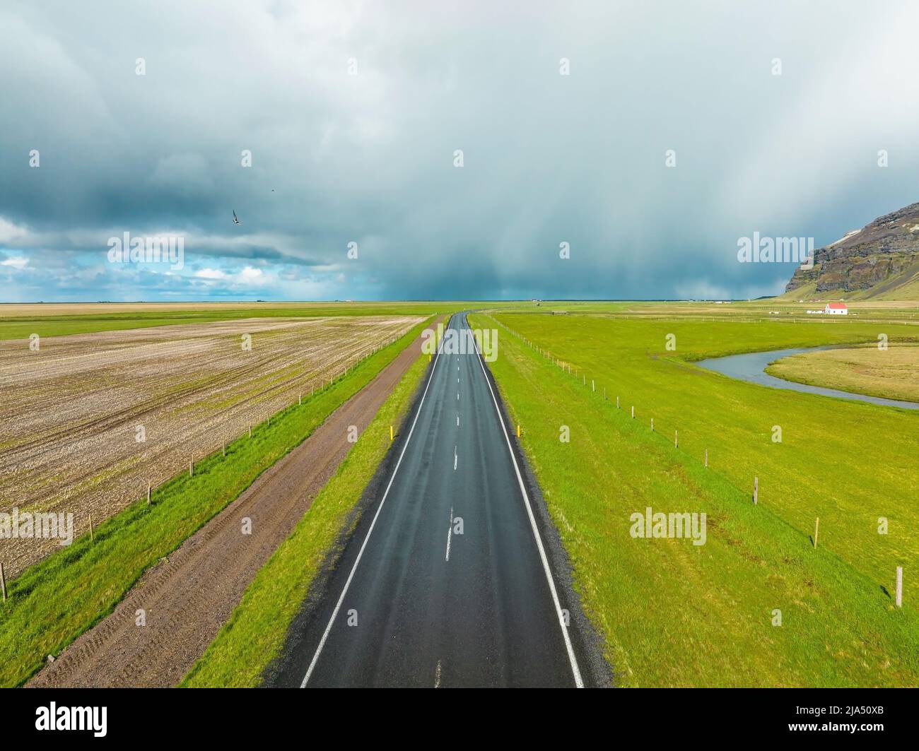 Endless road into the cloudy mountains and hills of Iceland during ...
