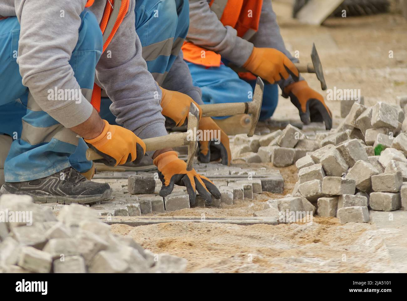 Pavers laying paving stones and creating a new sidewalk in the city ...
