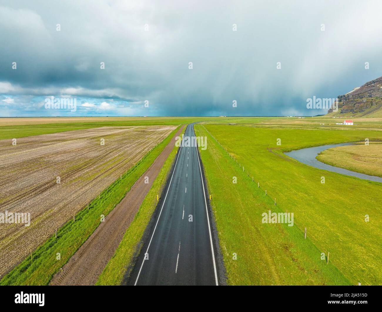 Endless road into the cloudy mountains and hills of Iceland during ...