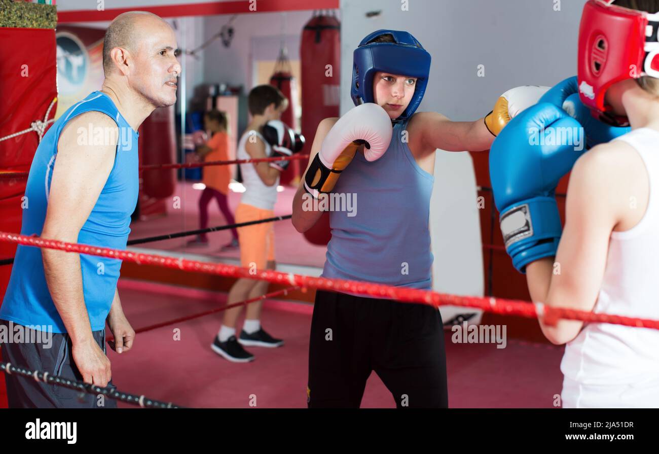 Teenage boxer exercising at boxing with coach Stock Photo - Alamy