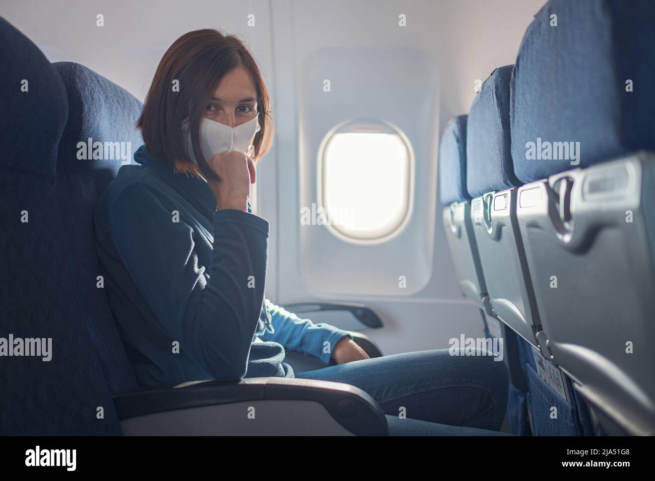 Young beautiful woman sitting at window of plane during the flight. new ...