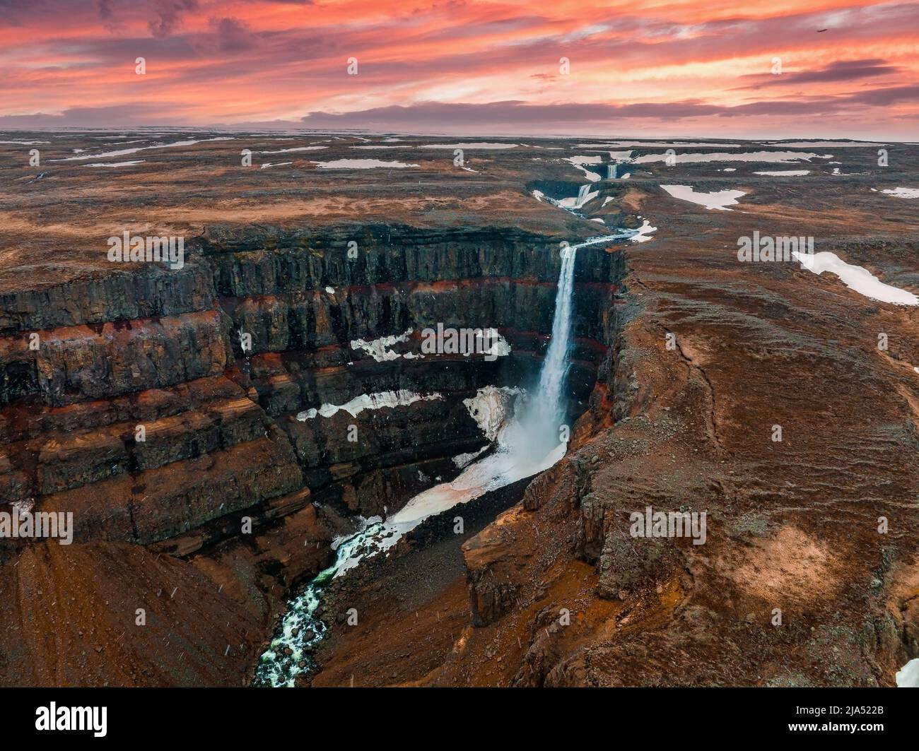 Aerial view on Hengifoss waterfall with red stripes sediments in ...