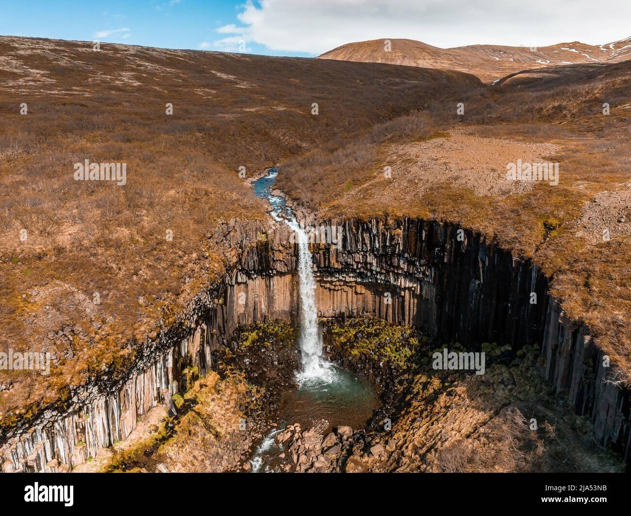 Aerial view of the Svartifoss waterfall surrounded by basalt columns ...