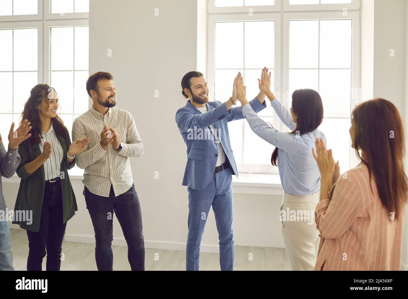 Businesswoman and businesswoman giving double high five at office ...