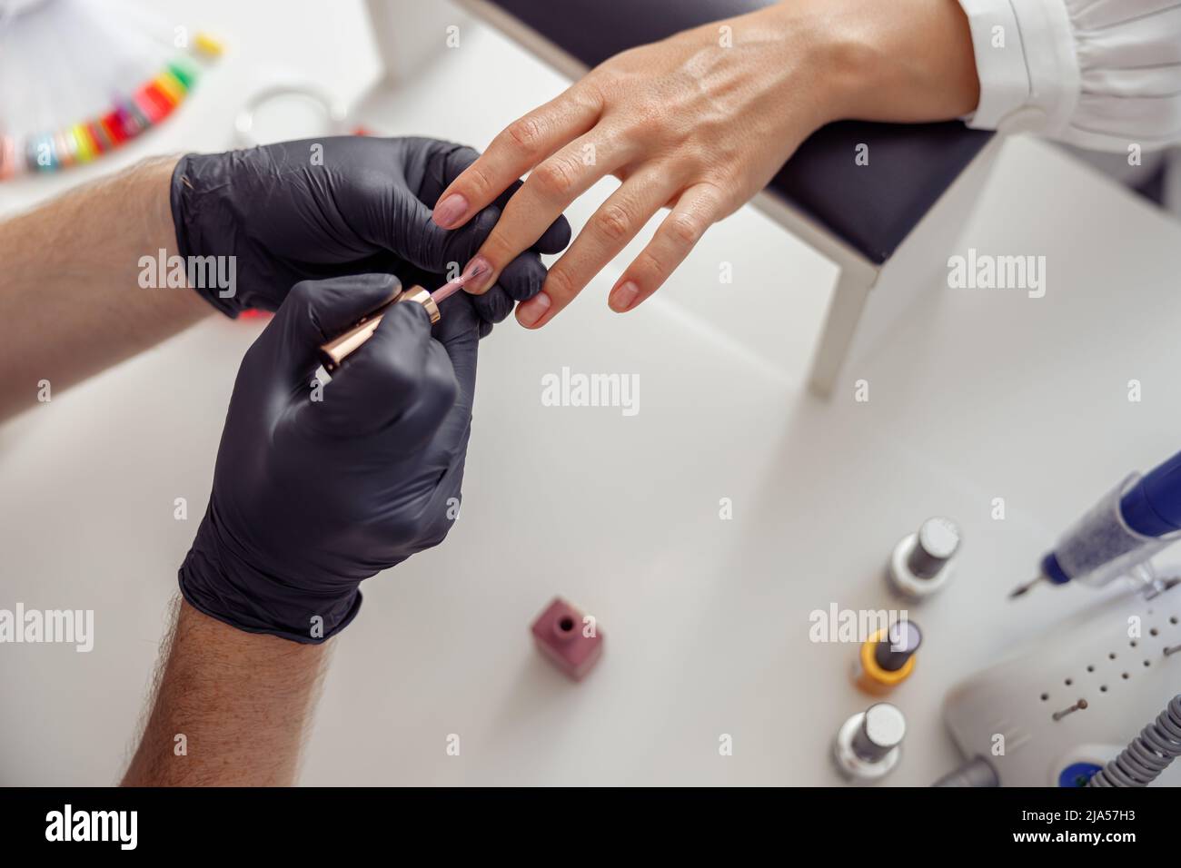 Nail technician applying polish to clients nails in salon Stock Photo ...