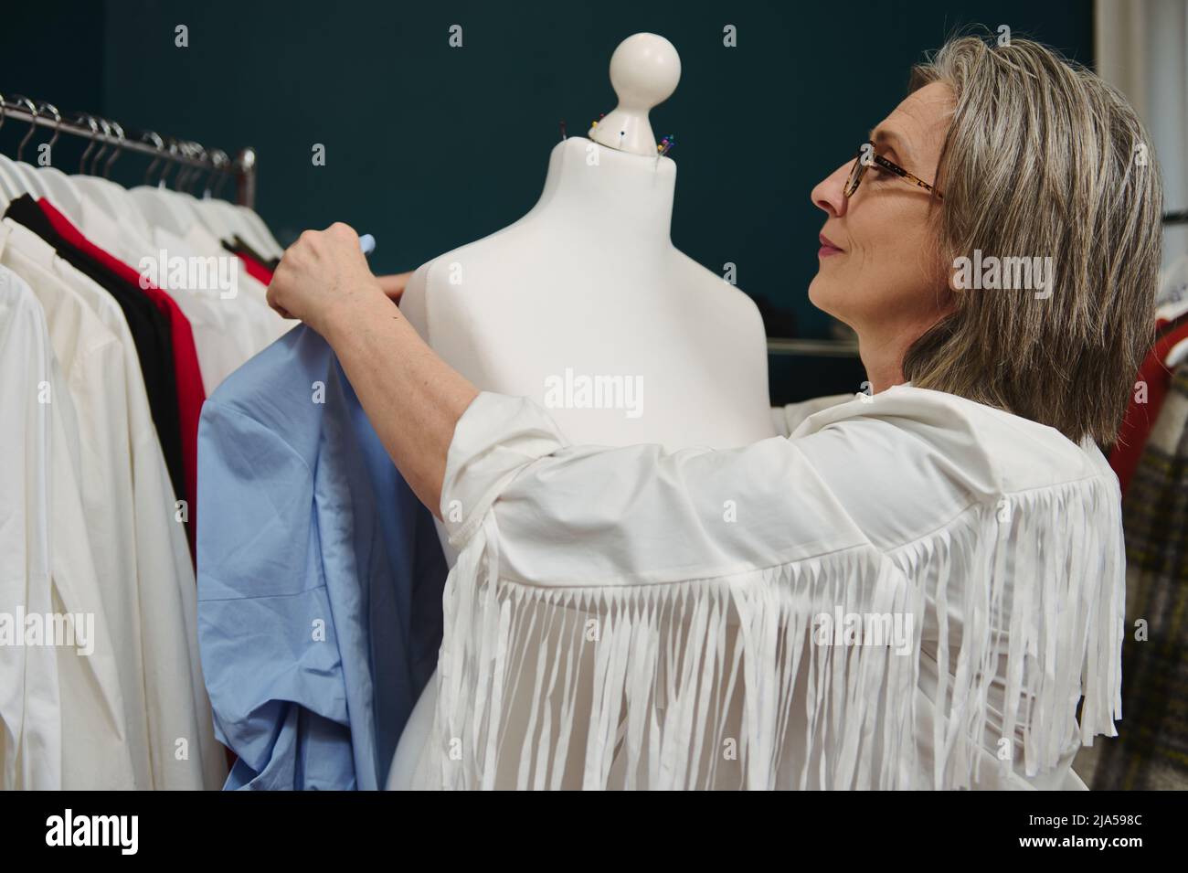 Elderly elegant Caucasian woman, fashion designer, dressmaker, tailor ...