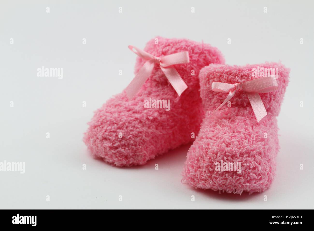 Two pink baby booties on white background with copy space Stock Photo ...