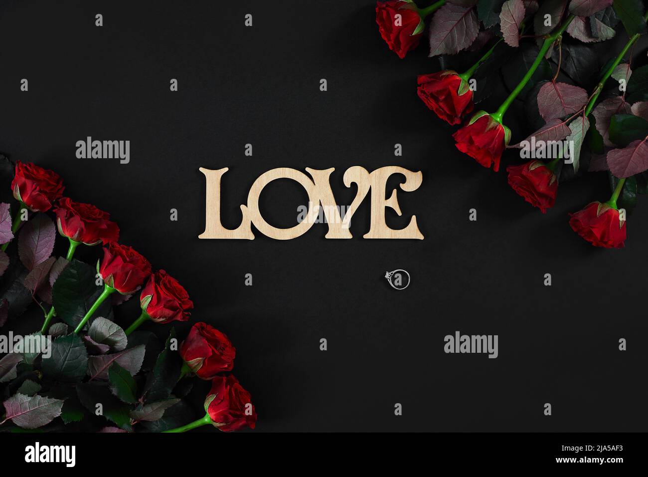 Red roses flowers with wooden word LOVE on black background with Stock ...