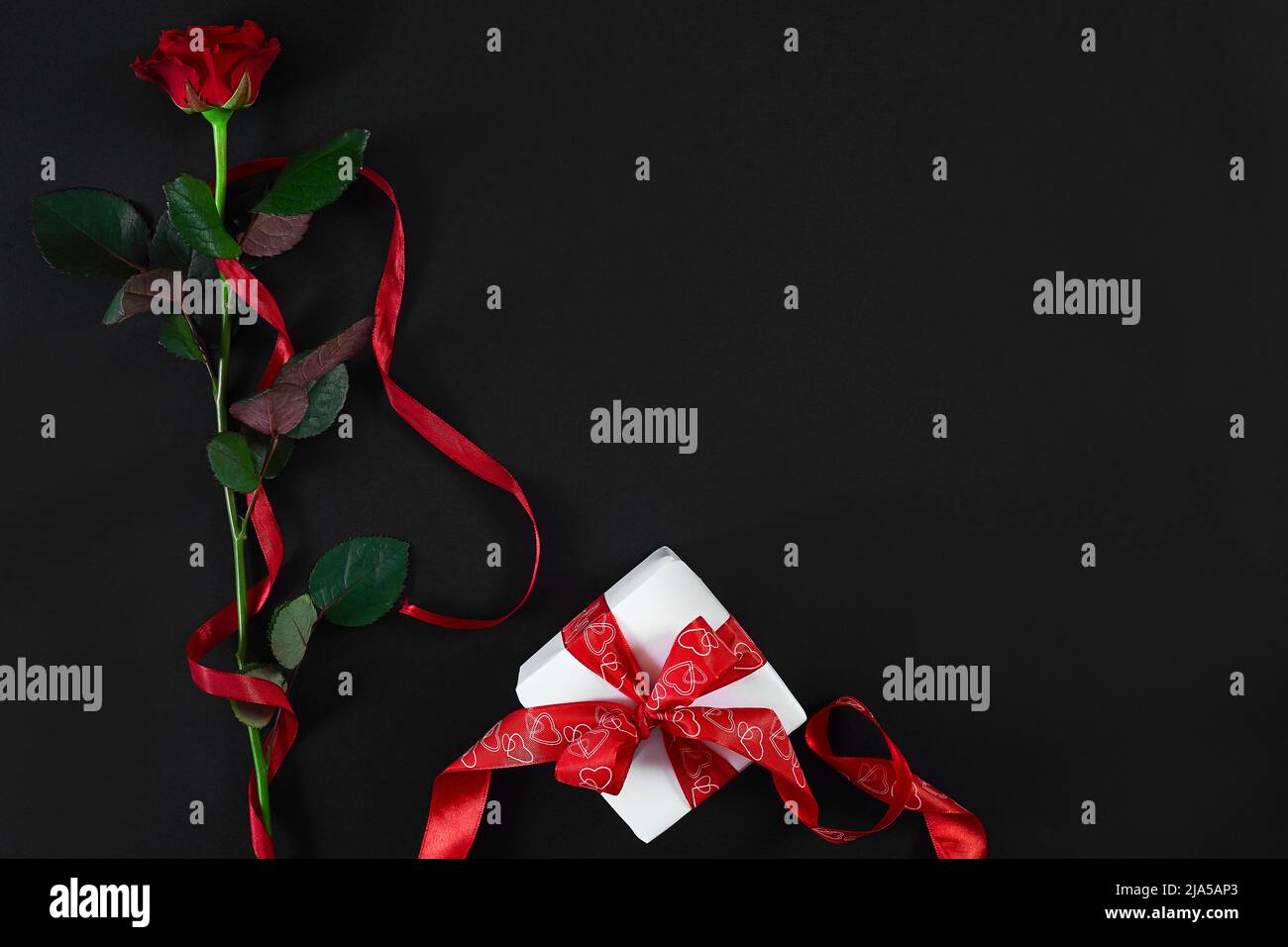 One dark red rose with red ribbon and gift box on black backgrou Stock ...