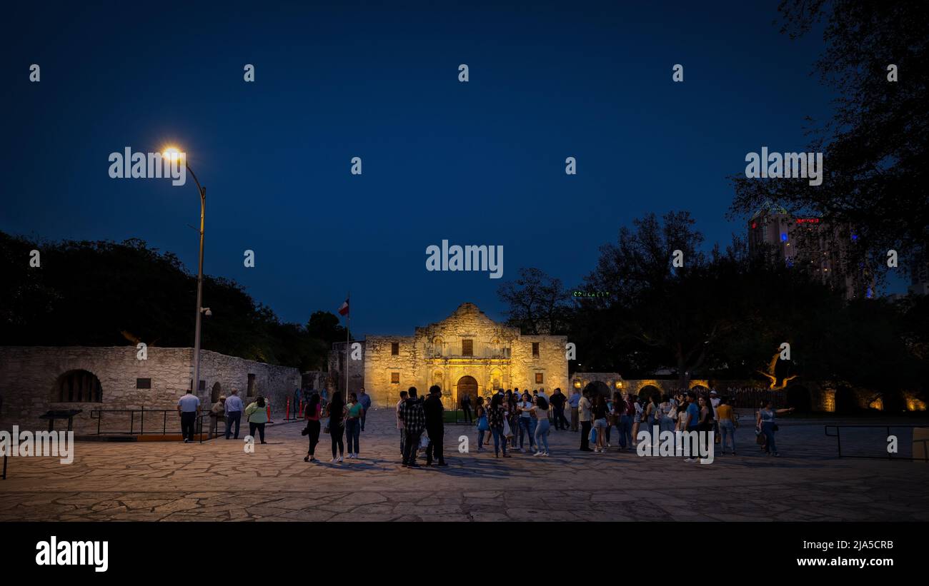 Tourist walk outside the Alamo, originally called Mission San Antonio ...