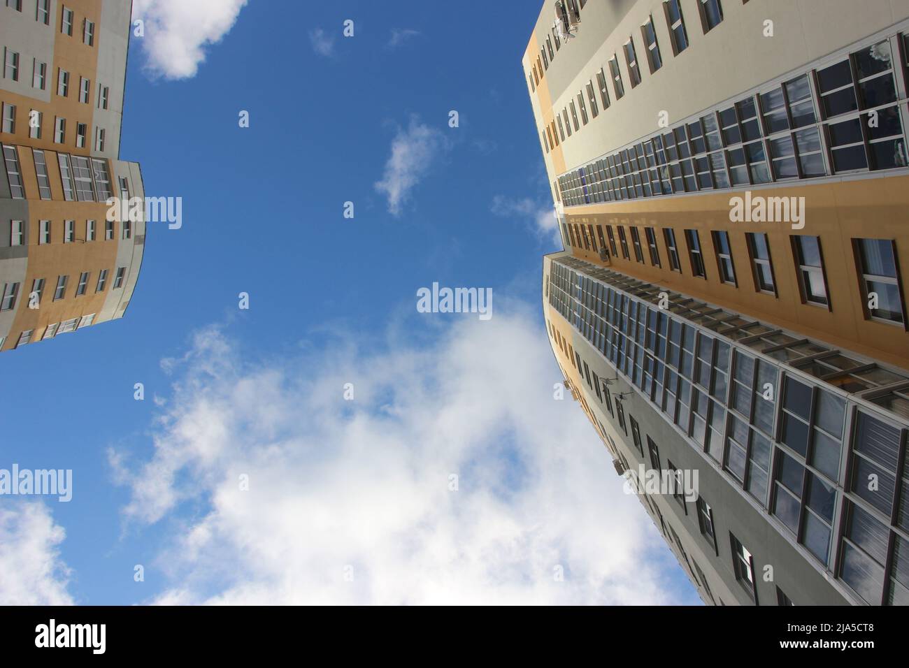 Tall skyscrapers down view shot with perspective under blue sky with ...