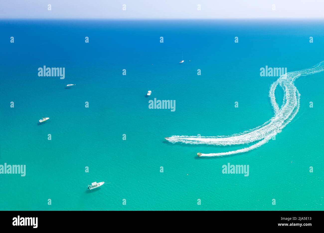 Water sports at seaside. Speed boat with slider leaving white trail ...