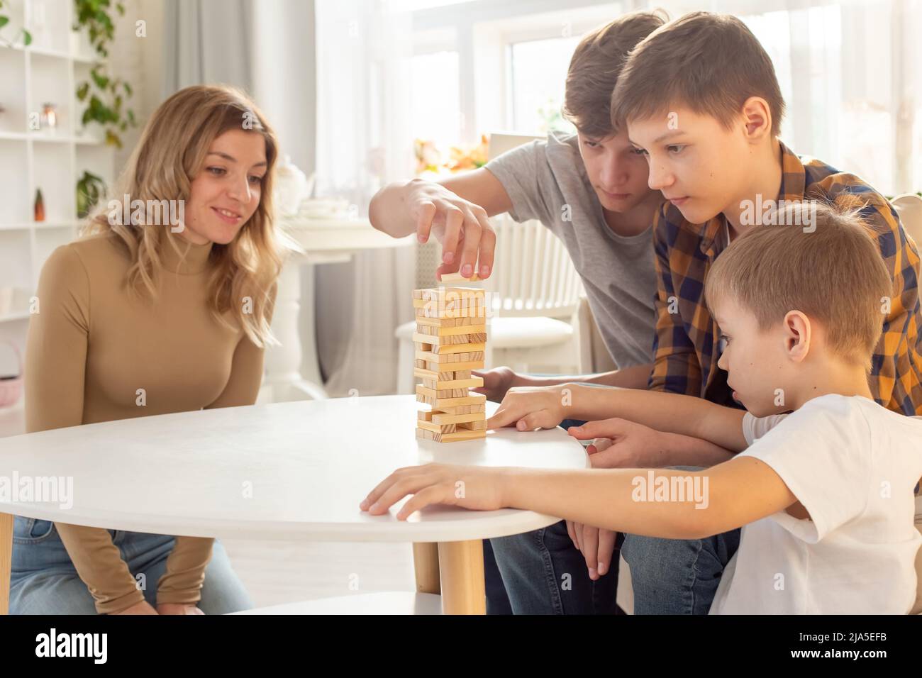 Family , in home enthusiastically play a board game made of wooden ...