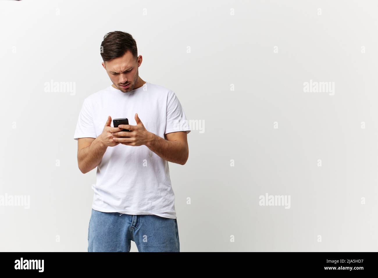 Angry confused irritated tanned handsome man in basic t-shirt type ...