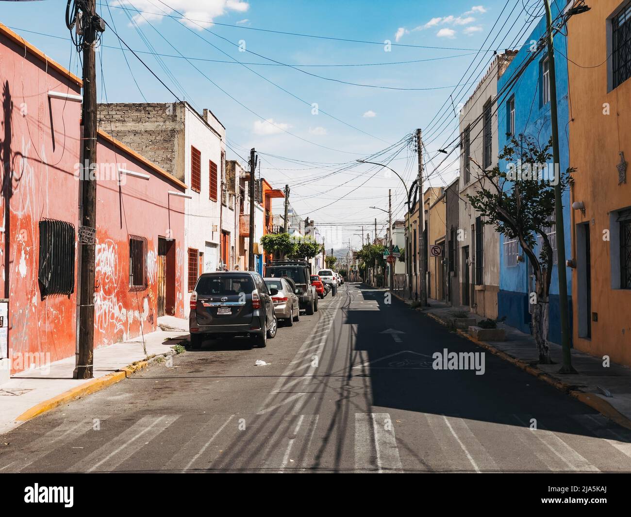 a colorful inner city street lined with two-story buildings in ...