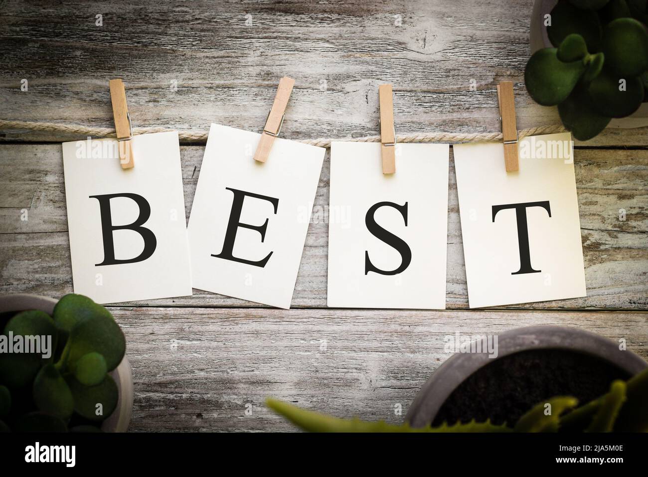 A set of printed cards spelling the word BEST on an aged wooden ...