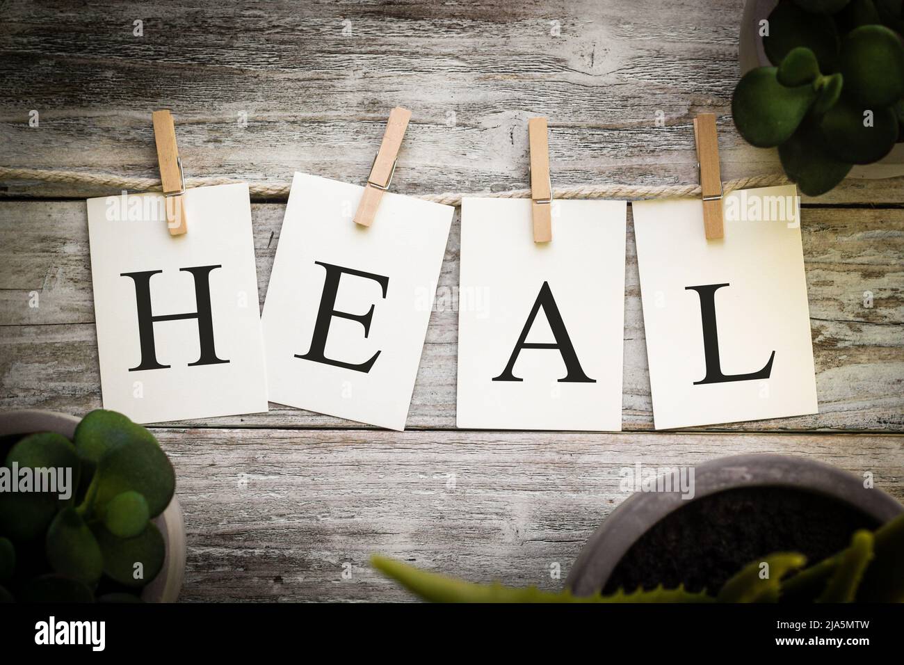 A set of printed cards spelling the word HEAL on an aged wooden ...