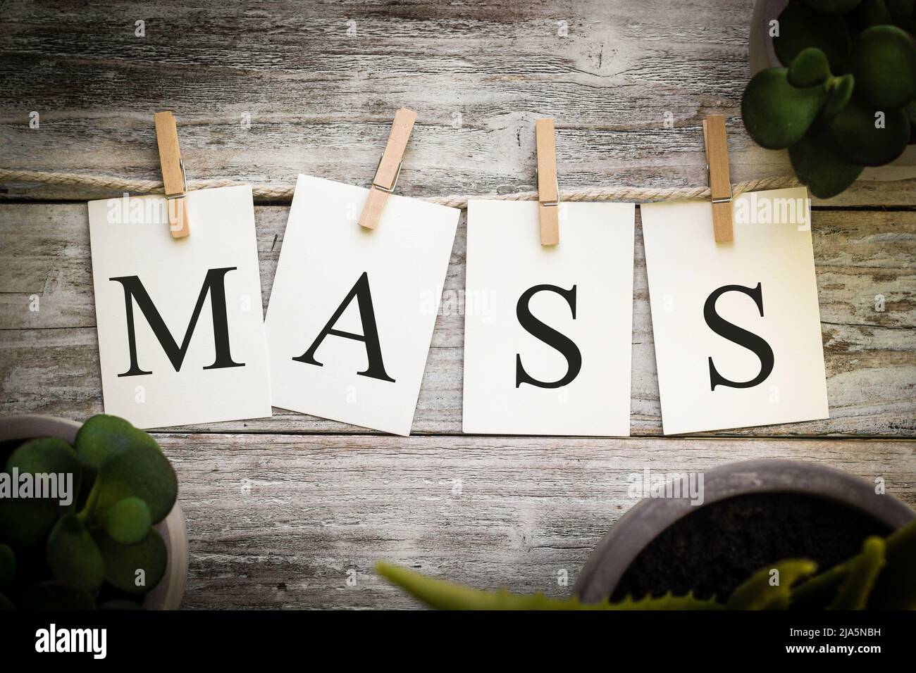 A set of printed cards spelling the word MASS on an aged wooden ...