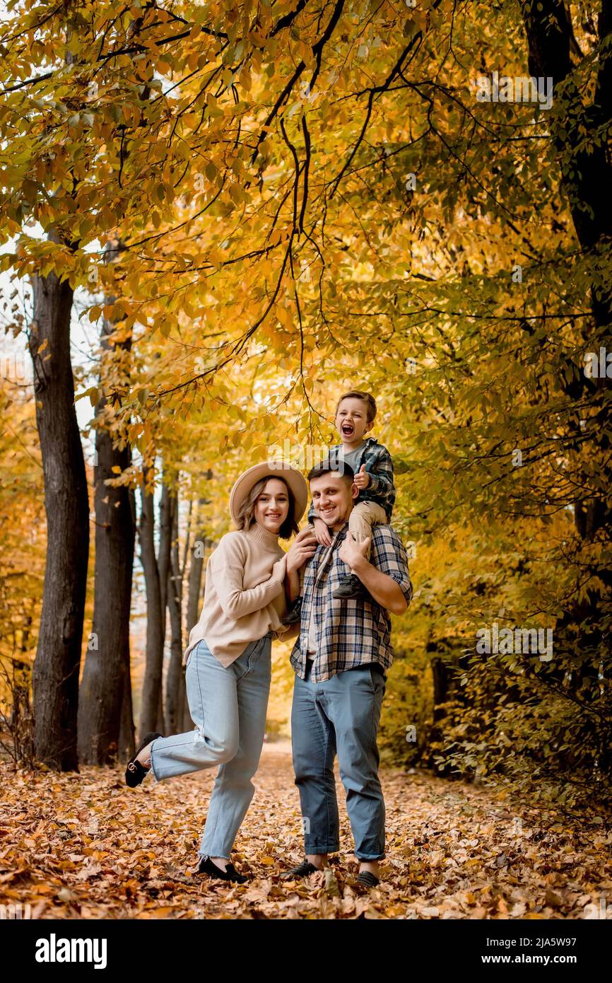 Portrait of happy young family on the background of autumn park. Mom ...